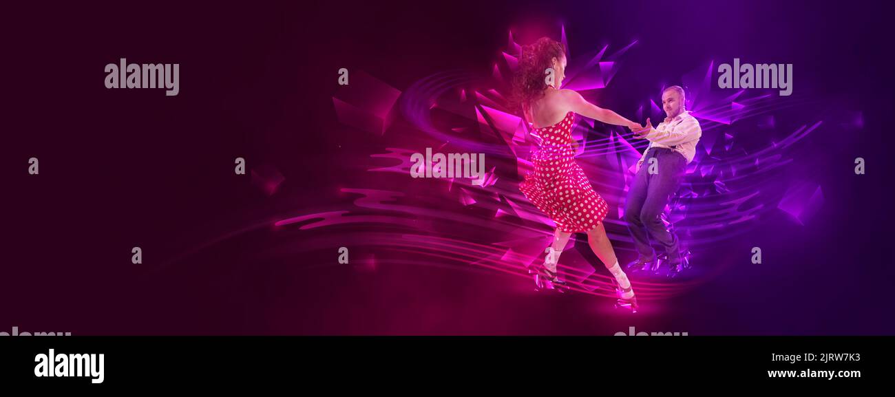 Excited man and woman, professional dancers dancing lindy hop over dark ...