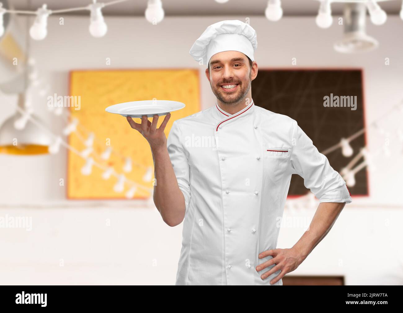 happy smiling male chef holding empty plate Stock Photo - Alamy