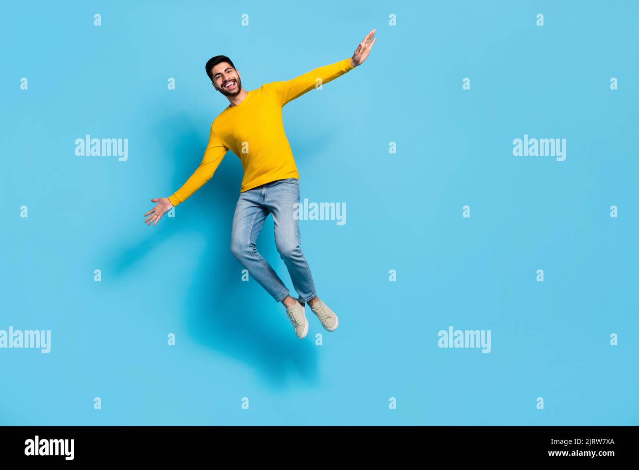 Full body portrait of active excited man hands wings jumping flight ...