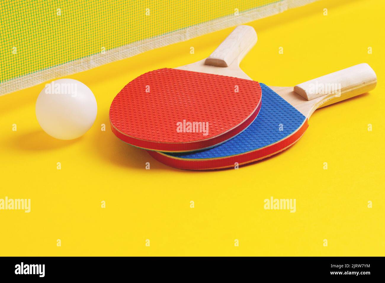 Closeup of table tennis equipment on yellow background. Pair of ping ...