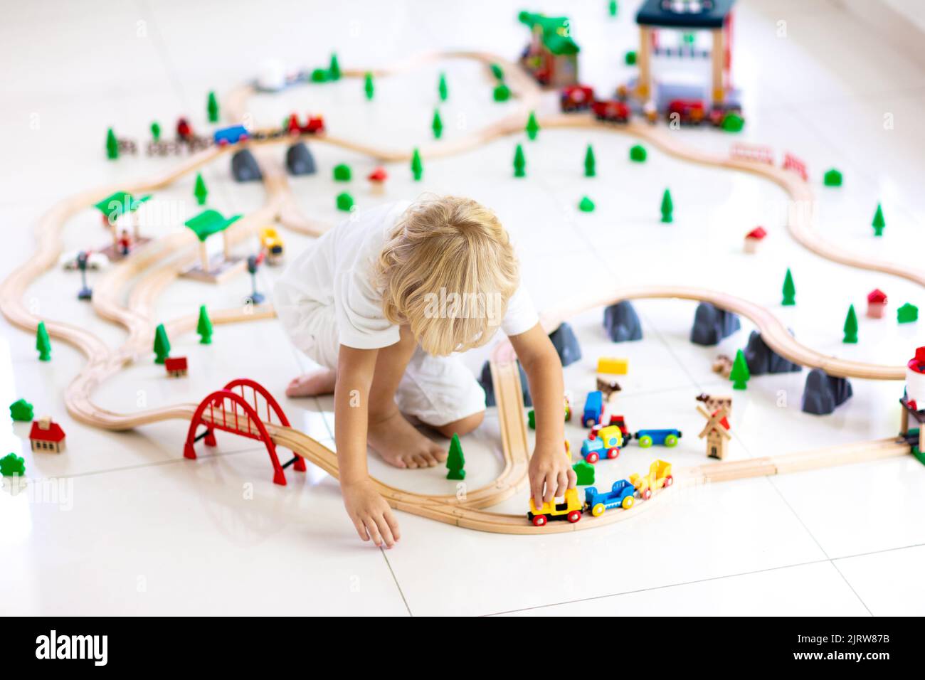 Kids play with wooden railway. Child with toy train. Educational toys ...