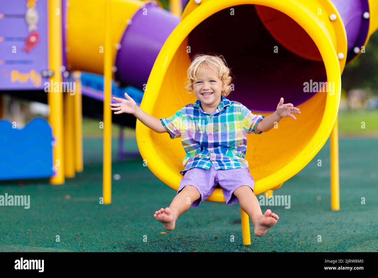 Child playing on outdoor playground. Kids play on school or ...