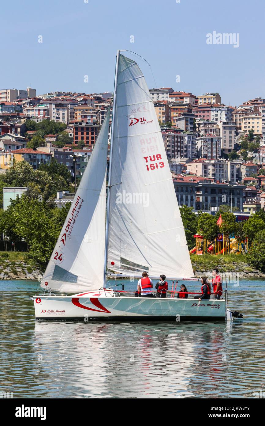 A vertical shot of people on a sailing boat and buildings in the ...