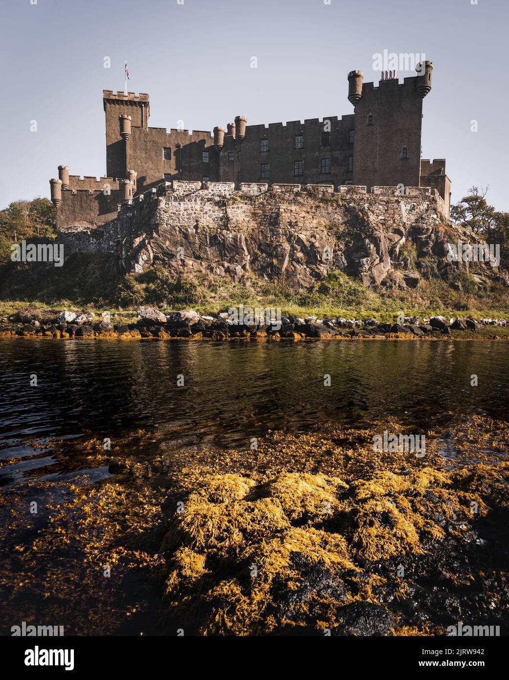 The vertical view of the Dunvegan castle on the riverbank under the ...