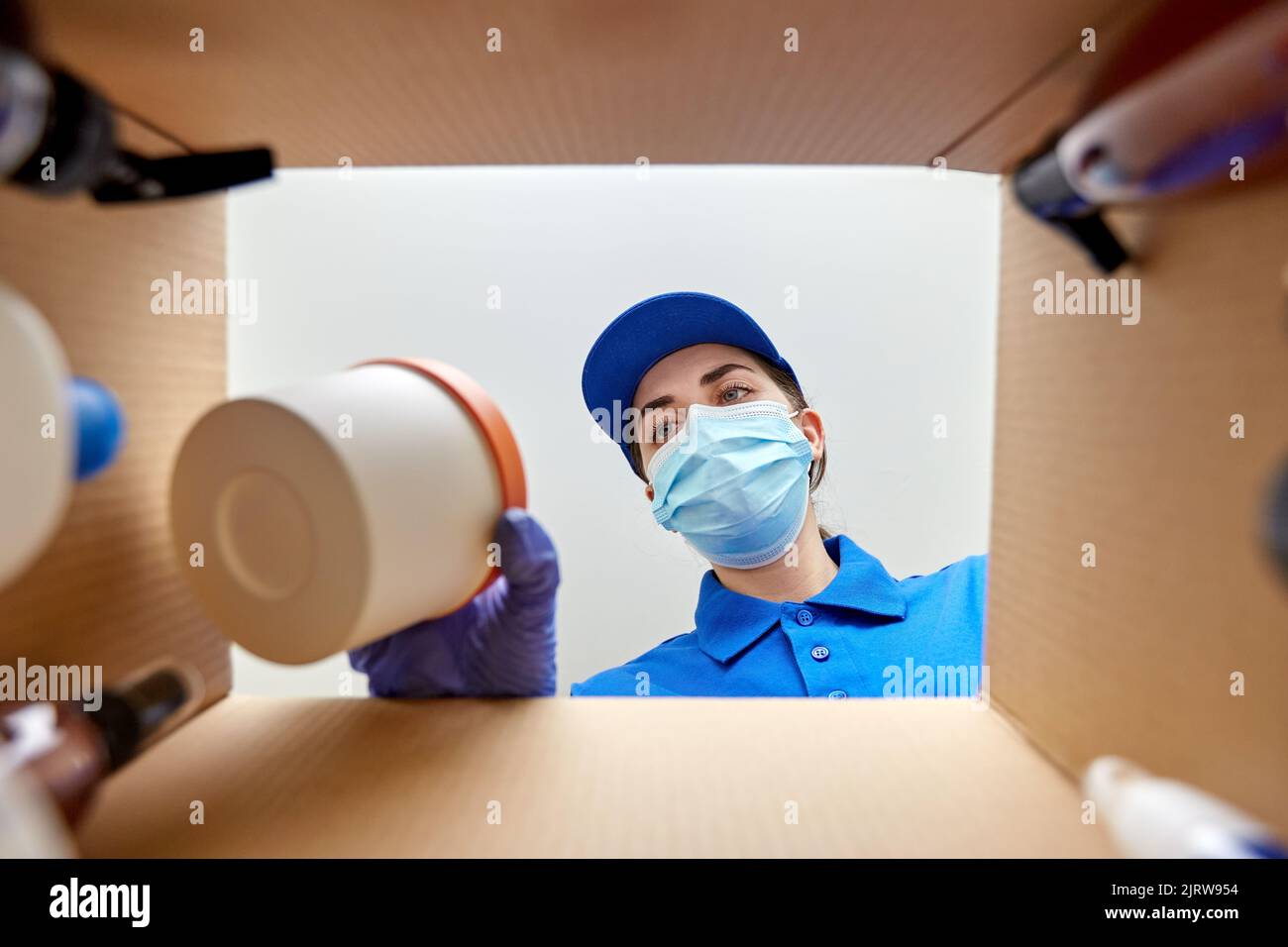 woman in mask packing parcel box with cosmetics Stock Photo - Alamy