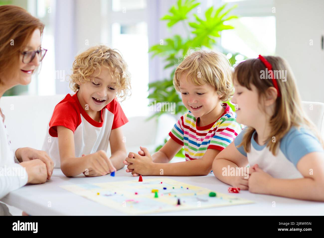 Family playing board game at home. Kids play strategic game. Little boy ...