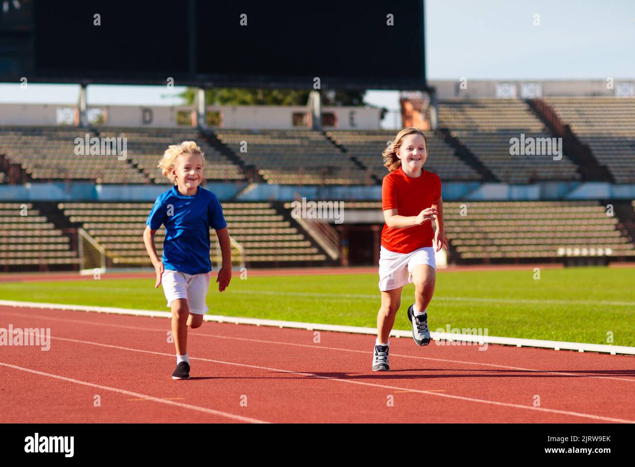 Child running in stadium. Kids run on outdoor track. Healthy sport ...