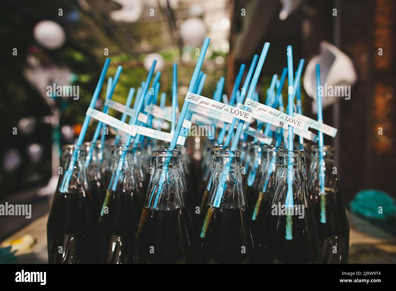 Rows with bottles and straws on the wedding table Stock Photo - Alamy