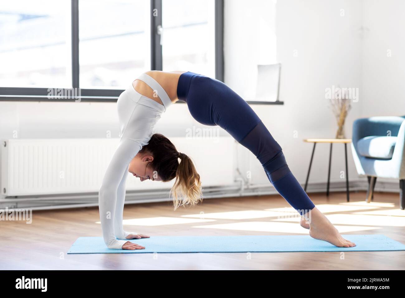 young woman doing bridge pose at yoga studio Stock Photo - Alamy
