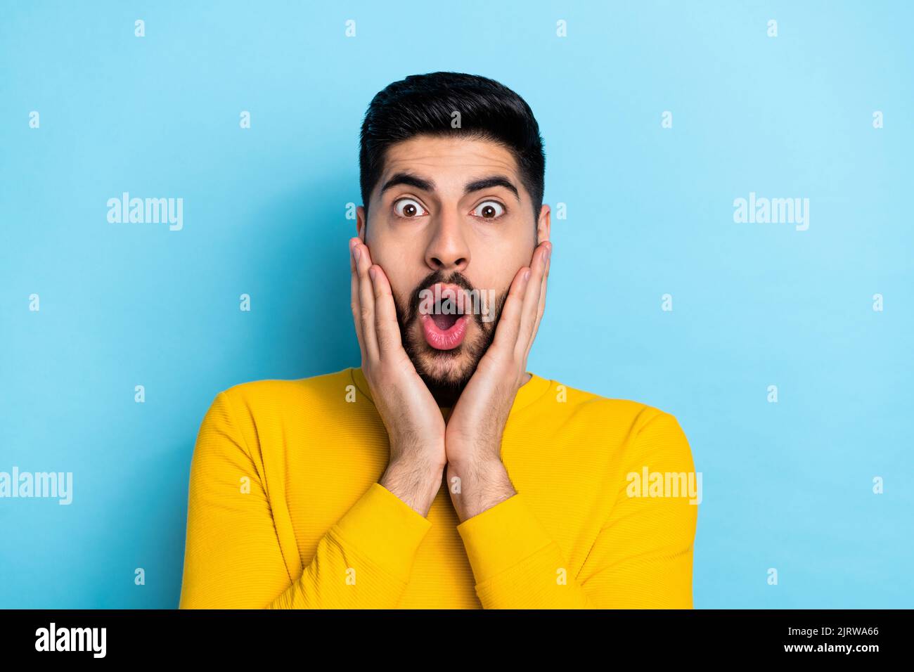 Photo of impressed handsome guy dressed yellow pullover arms cheeks ...