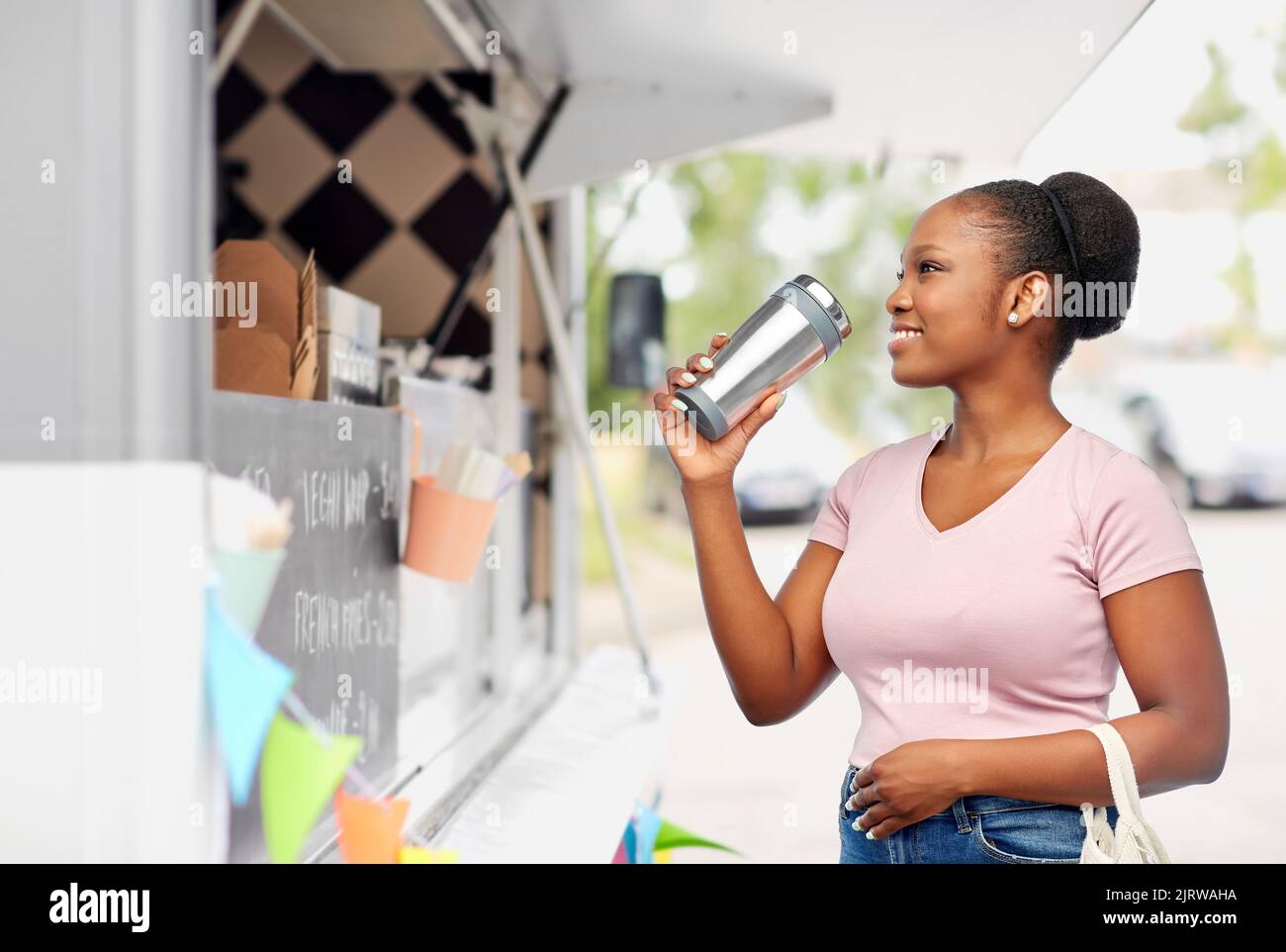 woman with tumbler and food in string bag Stock Photo - Alamy