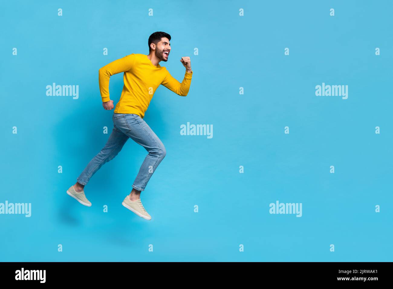Full size profile portrait of sporty cheerful man run jump look empty ...