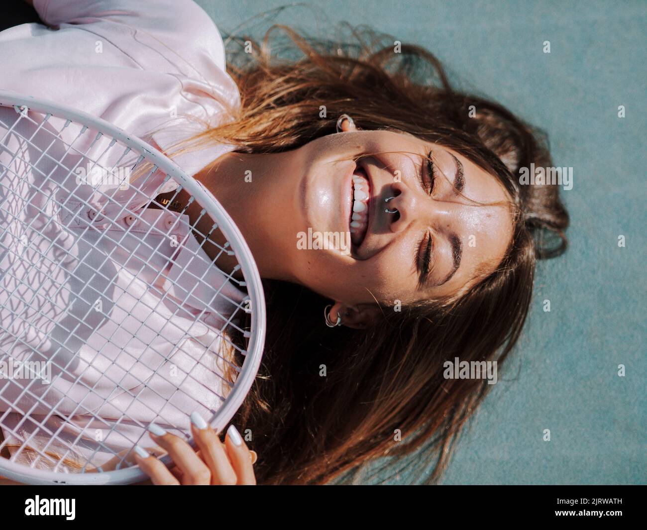 An overhead closeup shot of a female tennis player laying on court ...