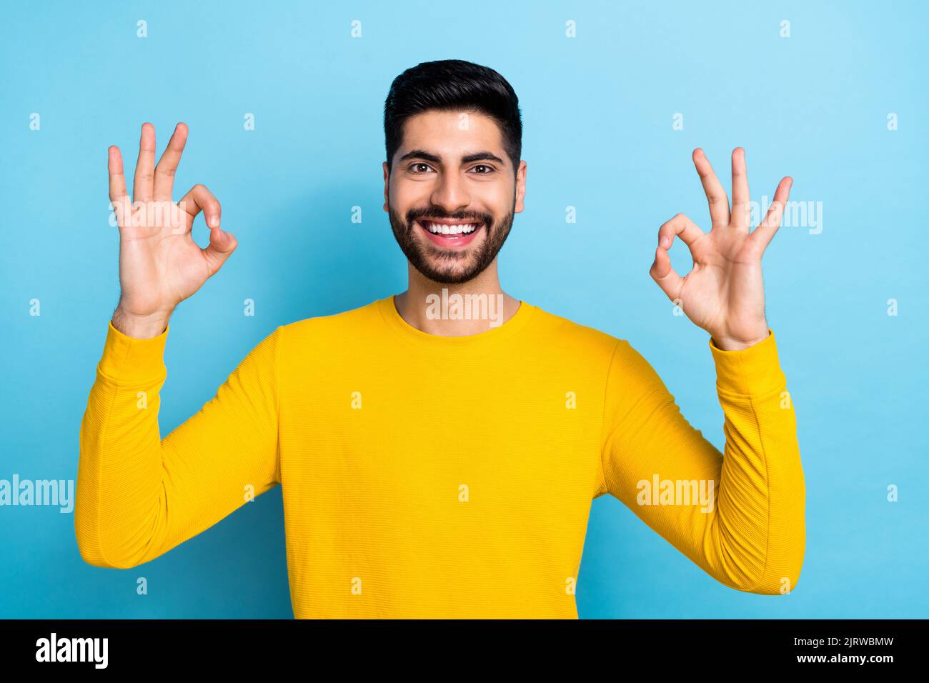 Photo of cheerful confident guy dressed yellow pullover showing two ...