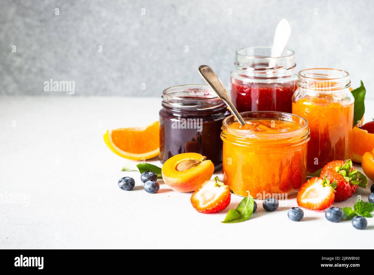 Homemade jam in glass jars at white table Stock Photo - Alamy