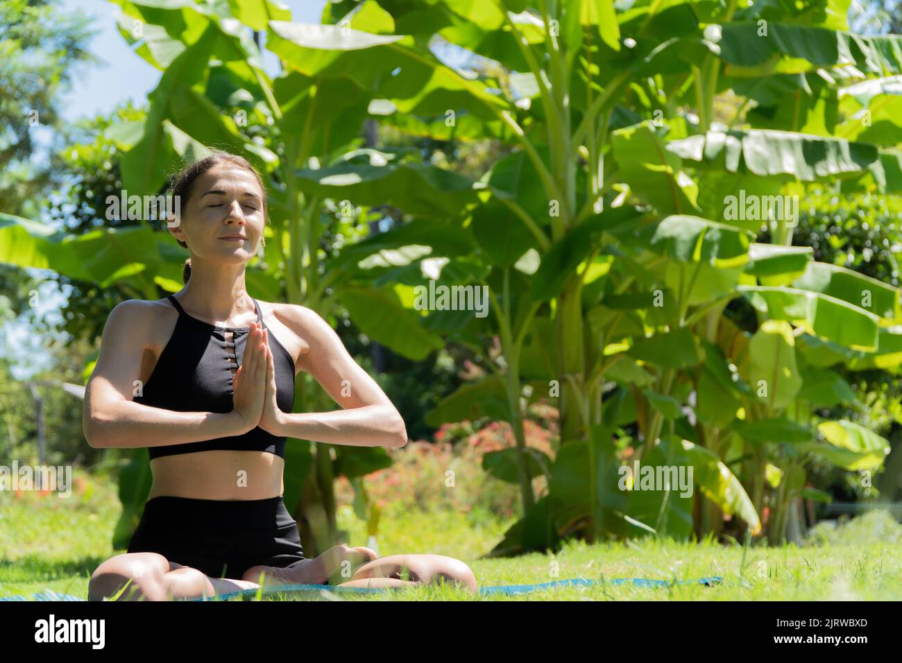 Meditation in nature against the background of palm trees, a woman in ...