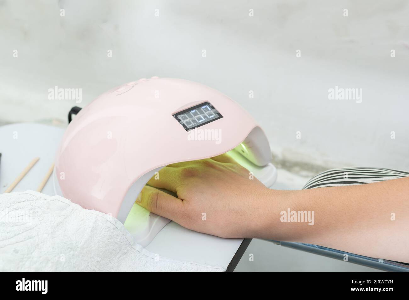 close-up of a latina girl's hand inside a 48 watt led nail lamp for ...