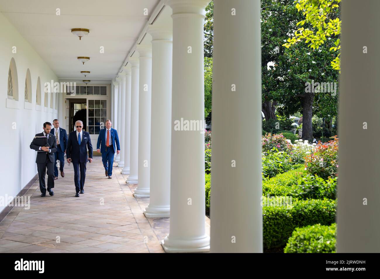 President Joe Biden walks along the West Colonnade of the White House ...