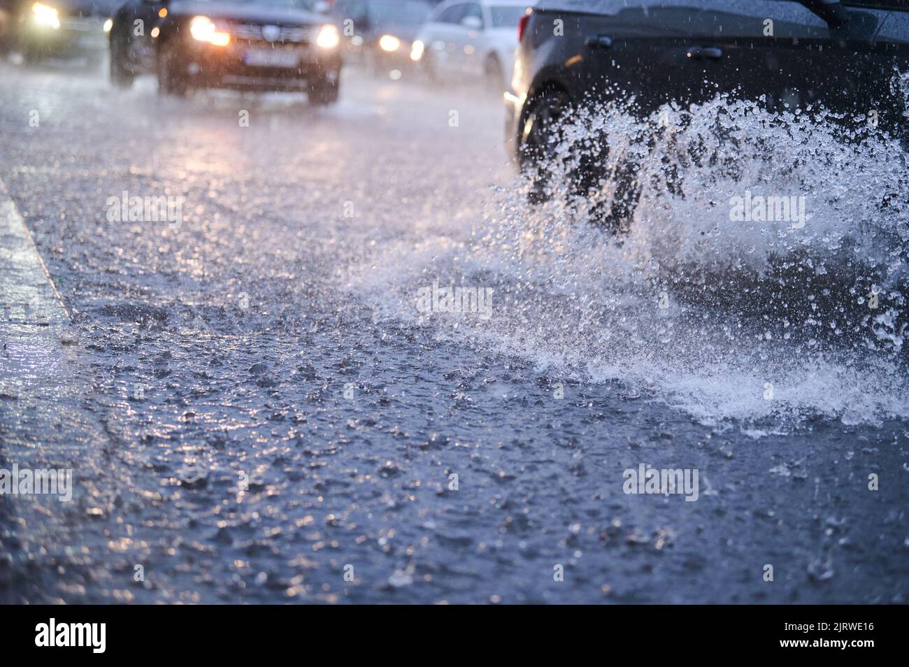 Berlin, Germany. 26th Aug, 2022. Cars drive through deep puddles that ...