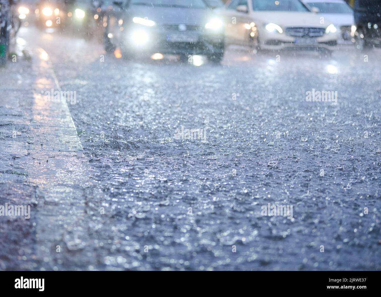Berlin, Germany. 26th Aug, 2022. Cars drive through deep puddles that ...