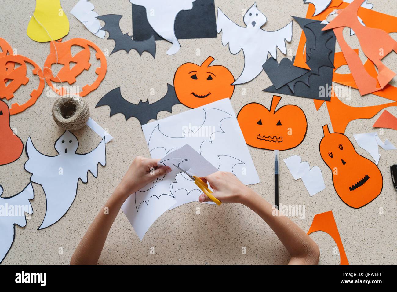 The hands of a girl with scissors make crafts for Halloween Stock Photo ...