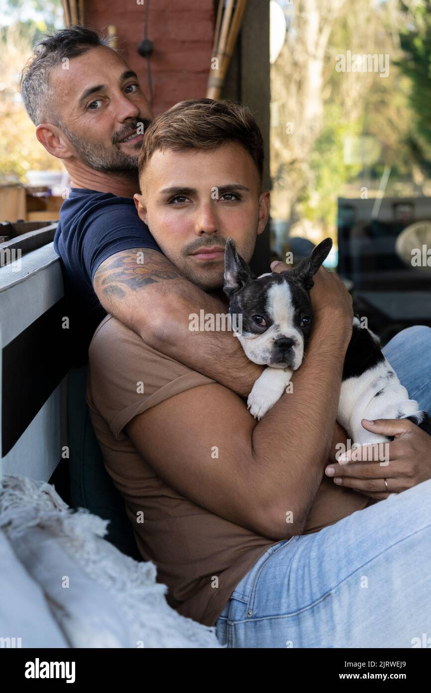 Gay male couple hugging while holding their French Bulldog Stock Photo ...