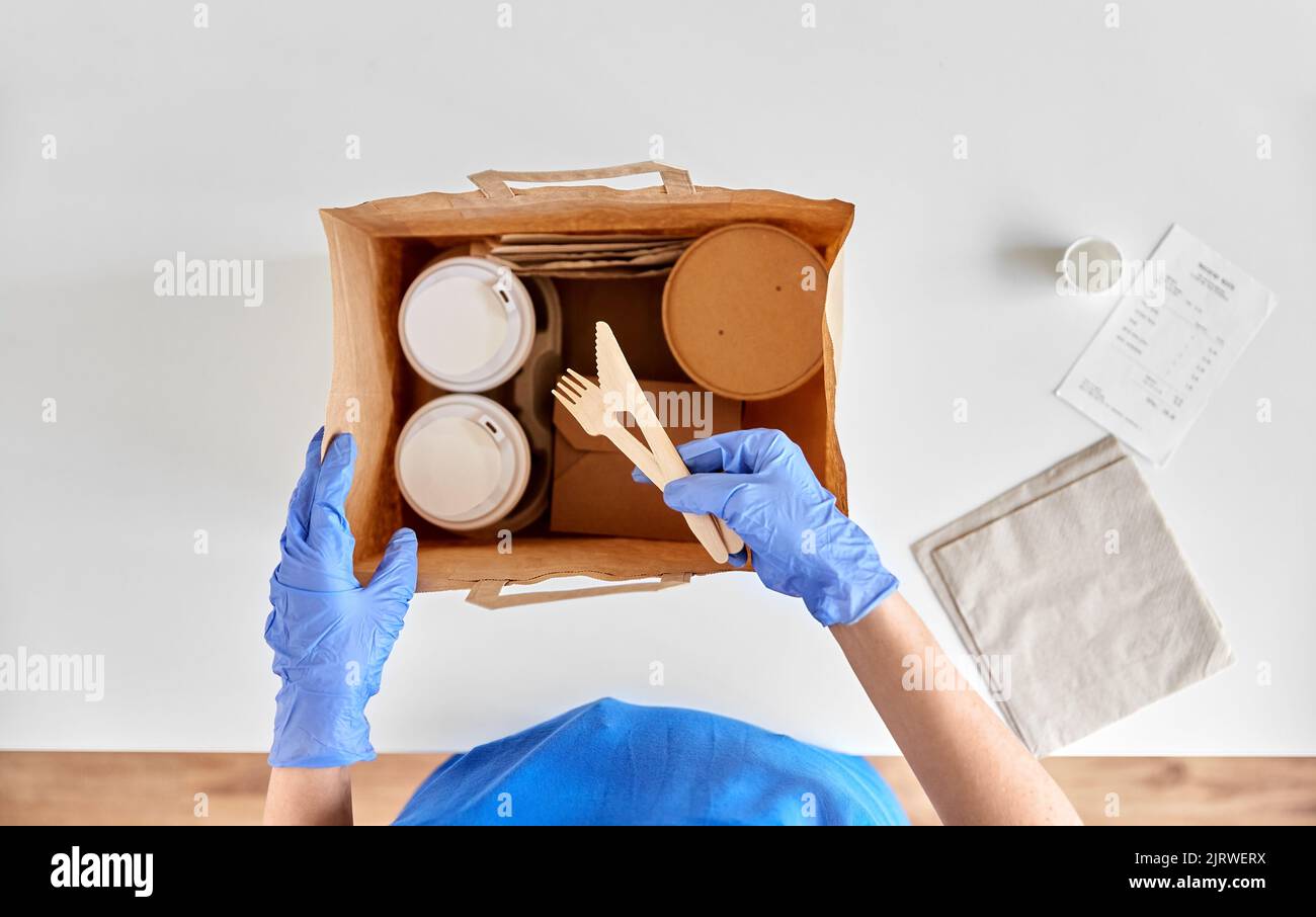 delivery woman in gloves packing food and drinks Stock Photo - Alamy