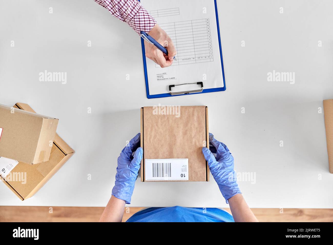 hands with parcel box and customer signing papers Stock Photo - Alamy