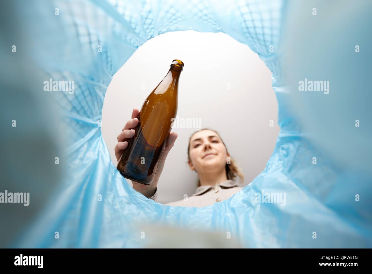 woman throwing glass bottle into trash can Stock Photo - Alamy