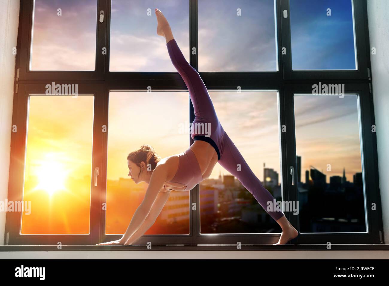 woman doing yoga exercise on window sill at studio Stock Photo - Alamy