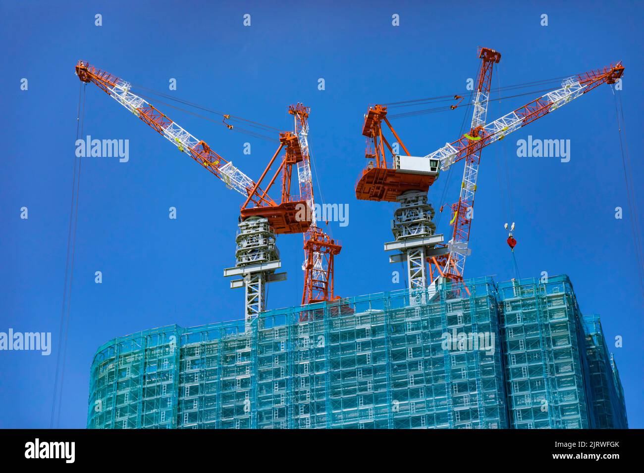 Cranes at the under construction daytime long shot Stock Photo - Alamy