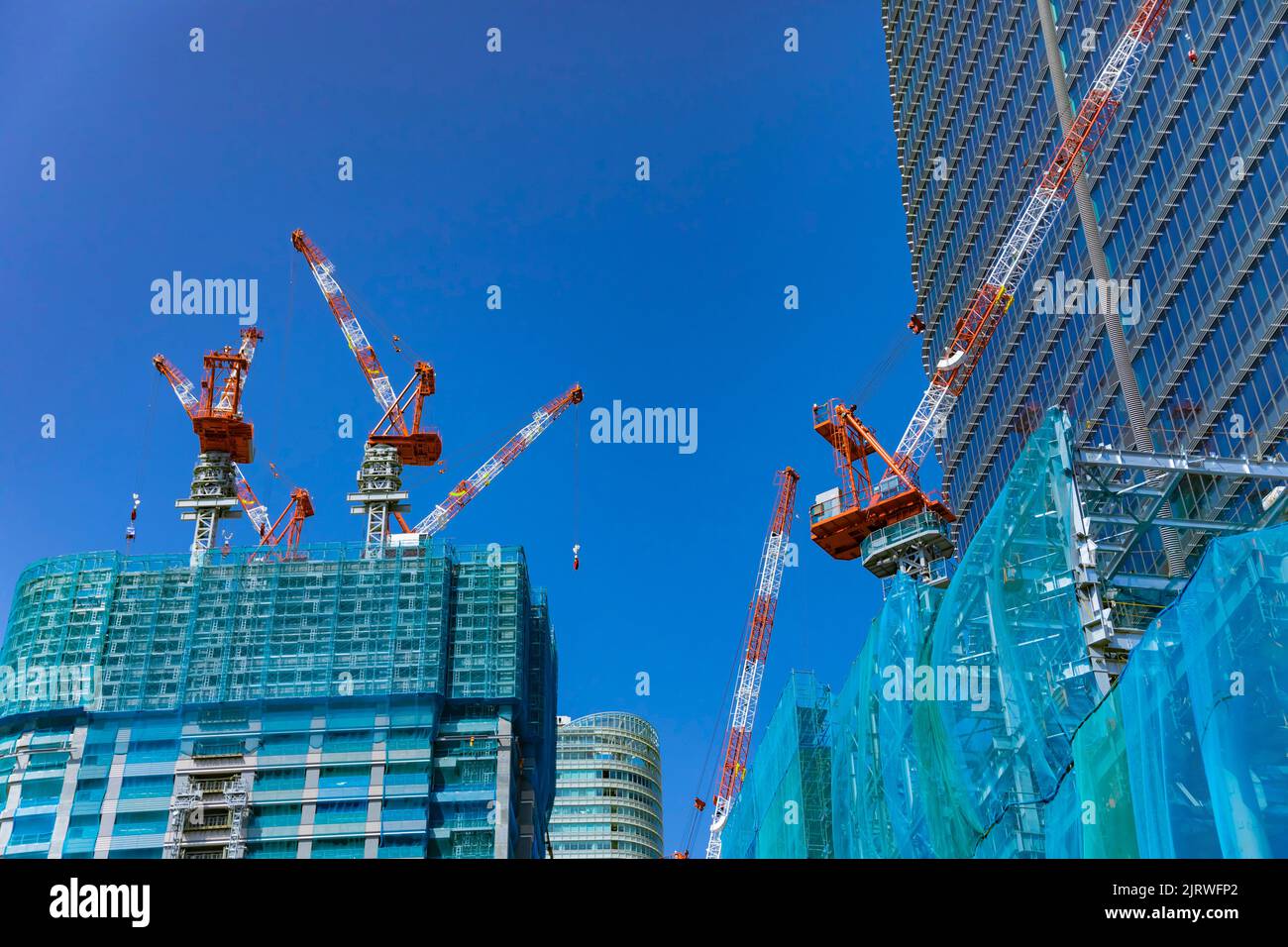 Cranes at the under construction daytime Stock Photo - Alamy