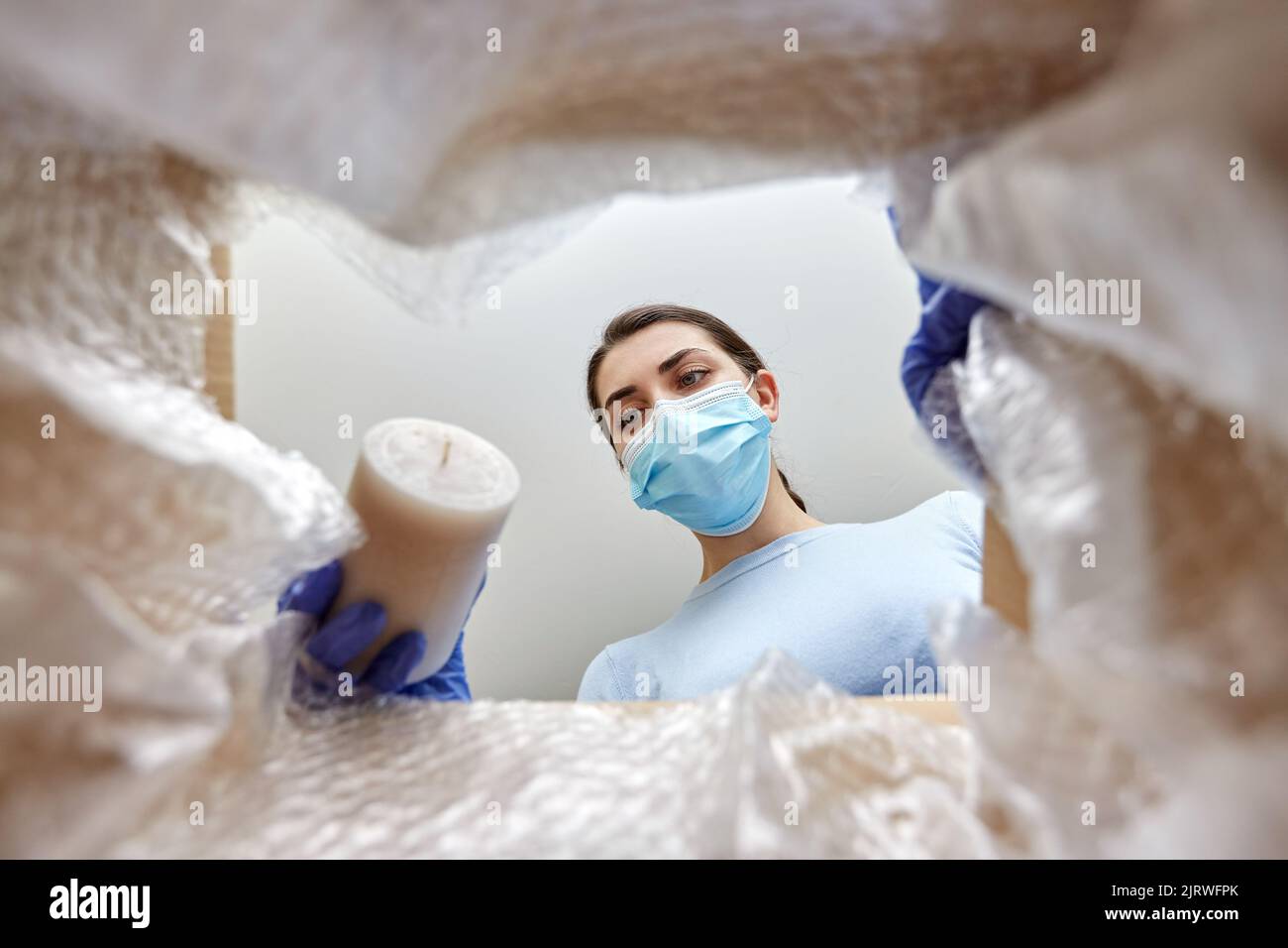 woman in mask packing candles into parcel box Stock Photo - Alamy
