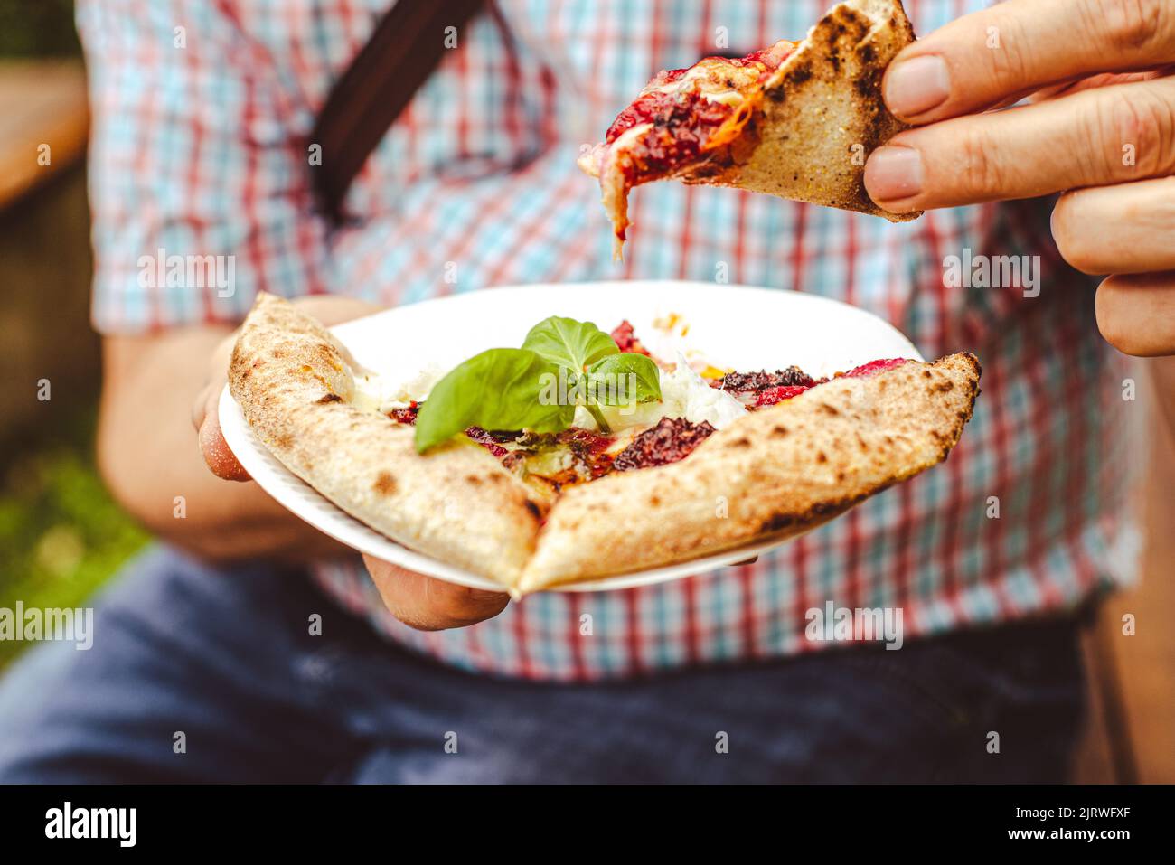 Man holding a slice of pizza Stock Photo - Alamy