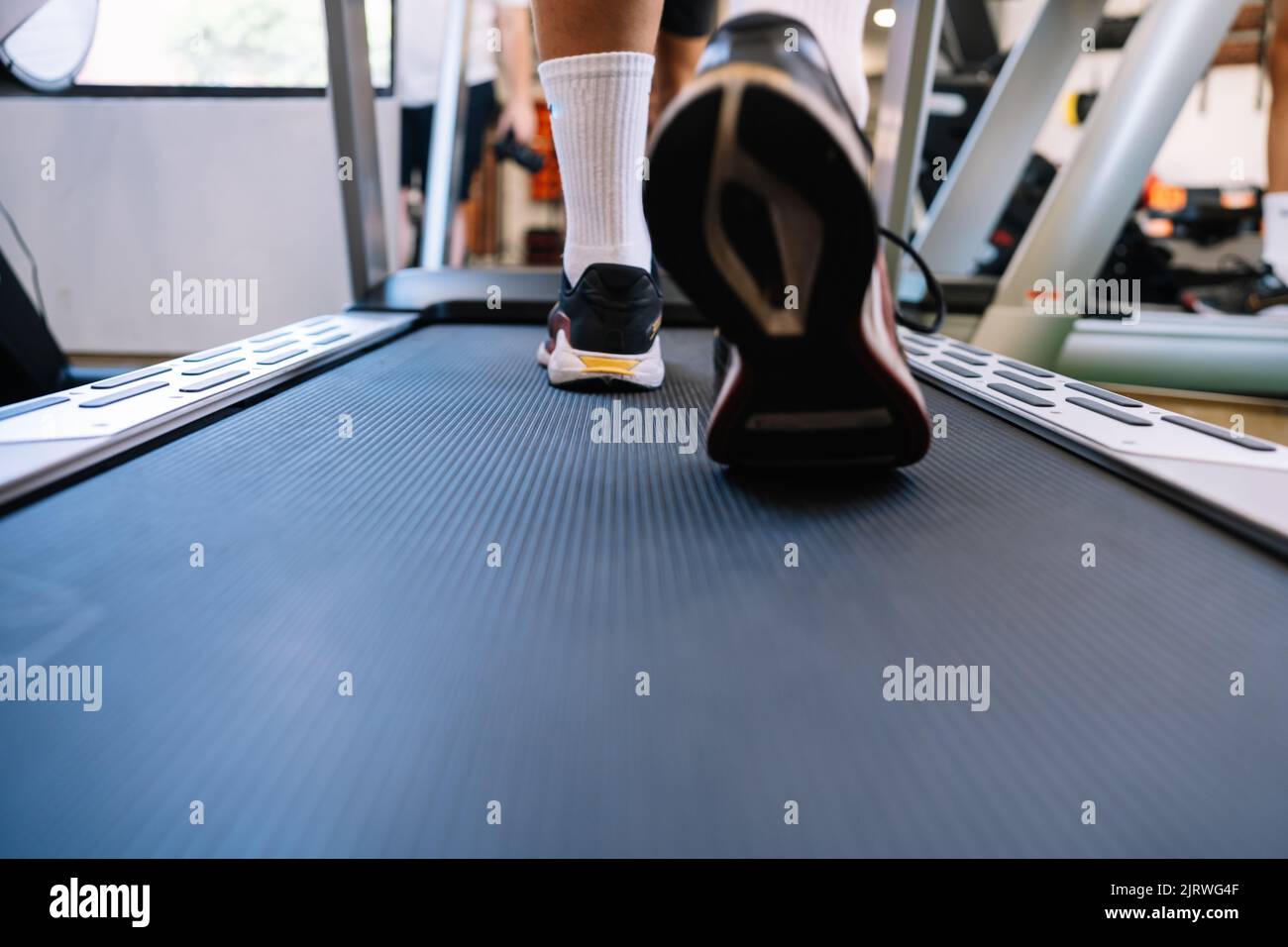 Ground level of unrecognizable male athlete in sneakers walking on ...