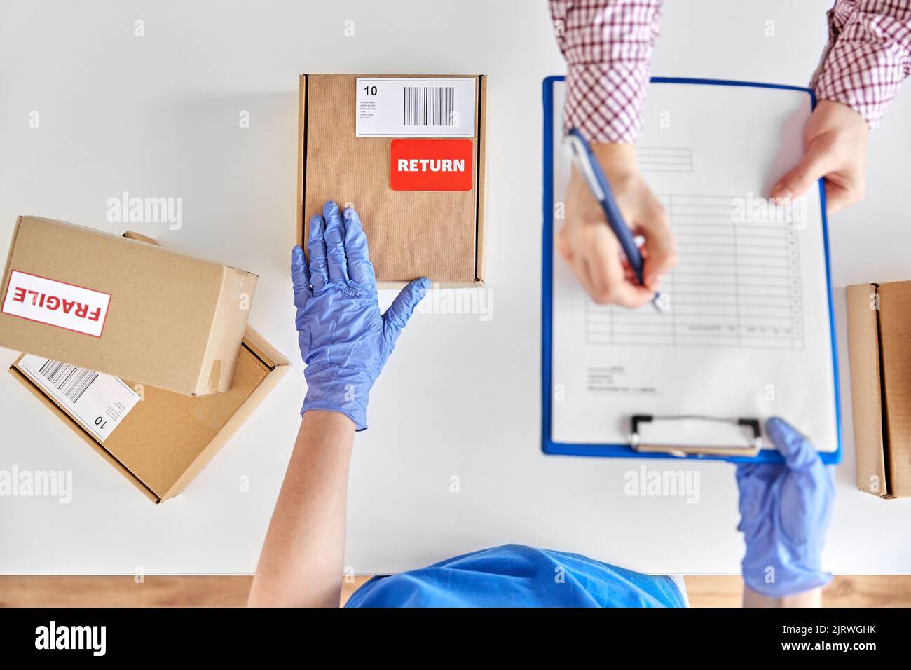 customer making return of parcel and signing papers Stock Photo - Alamy