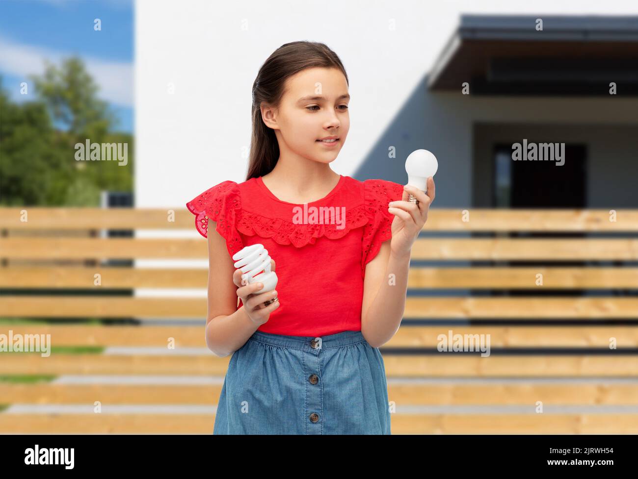 smiling girl comparing different light bulbs Stock Photo - Alamy