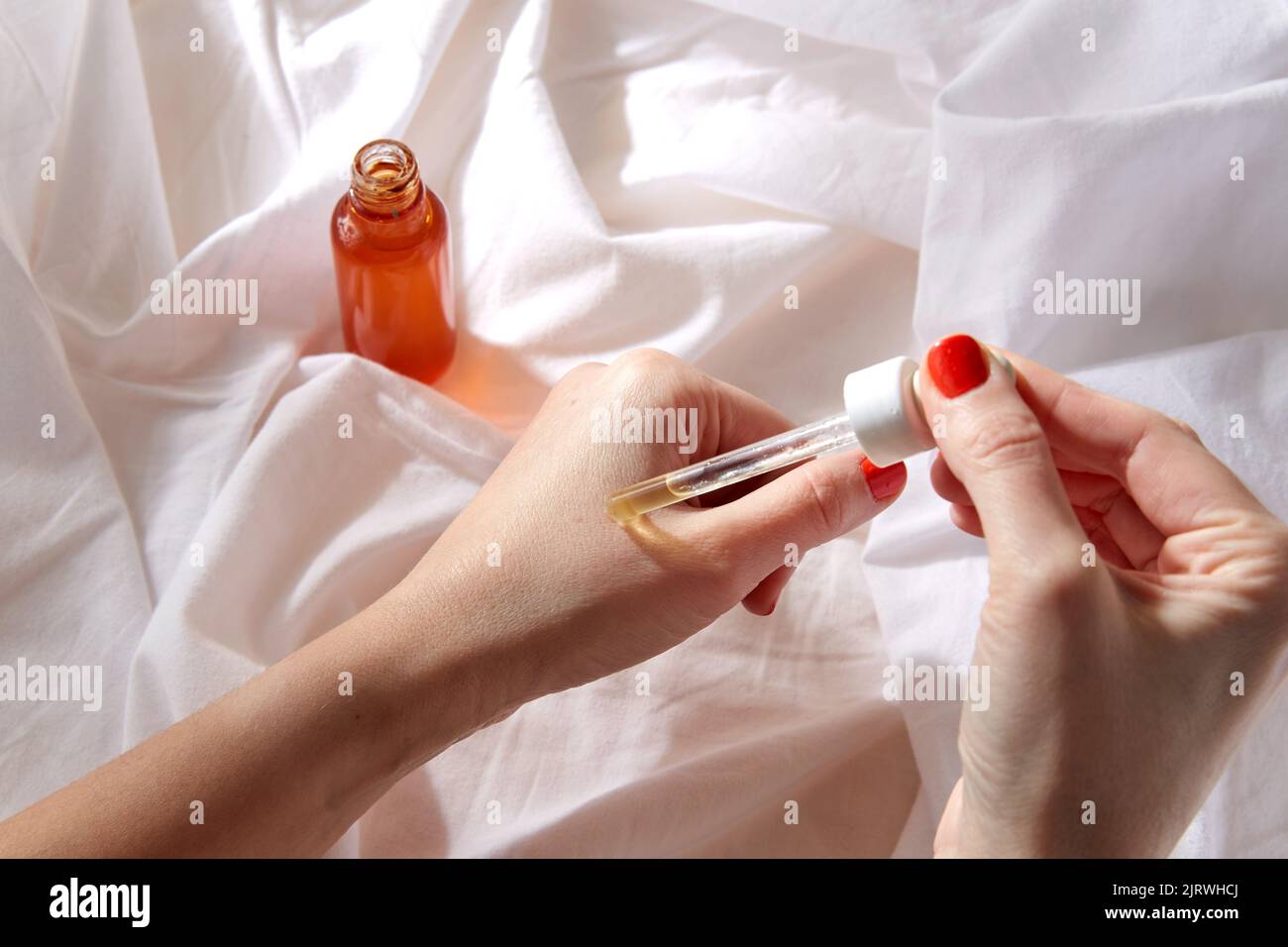 female hands with dropper applying serum to skin Stock Photo - Alamy