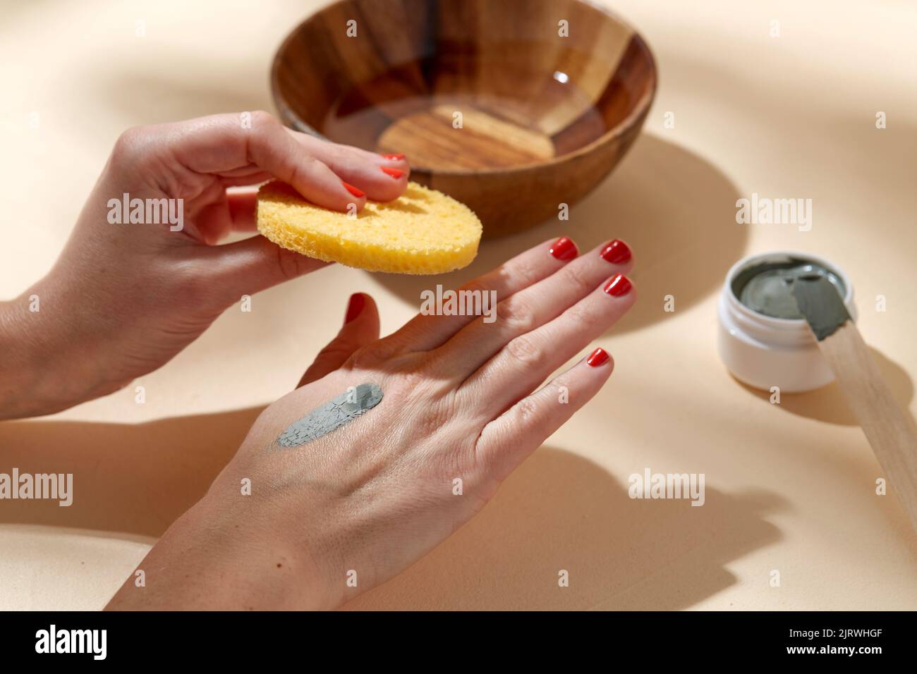 hands applying blue cosmetic clay mask to skin Stock Photo - Alamy