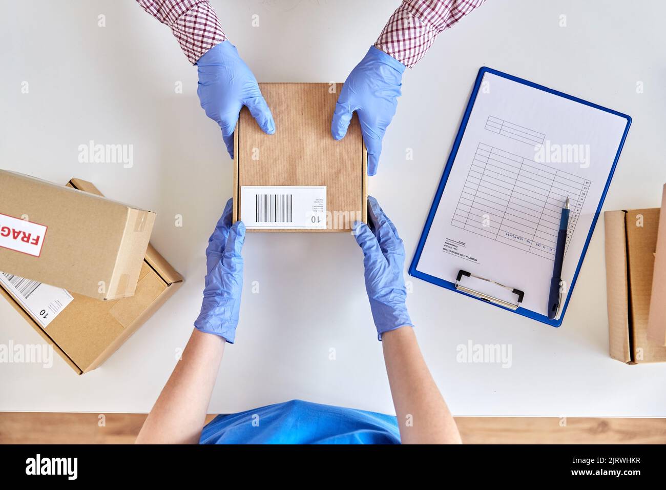 hands in gloves giving parcel box to customer Stock Photo - Alamy