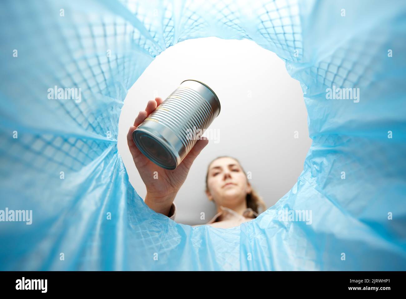 woman throwing tin can into rubbish bin Stock Photo - Alamy