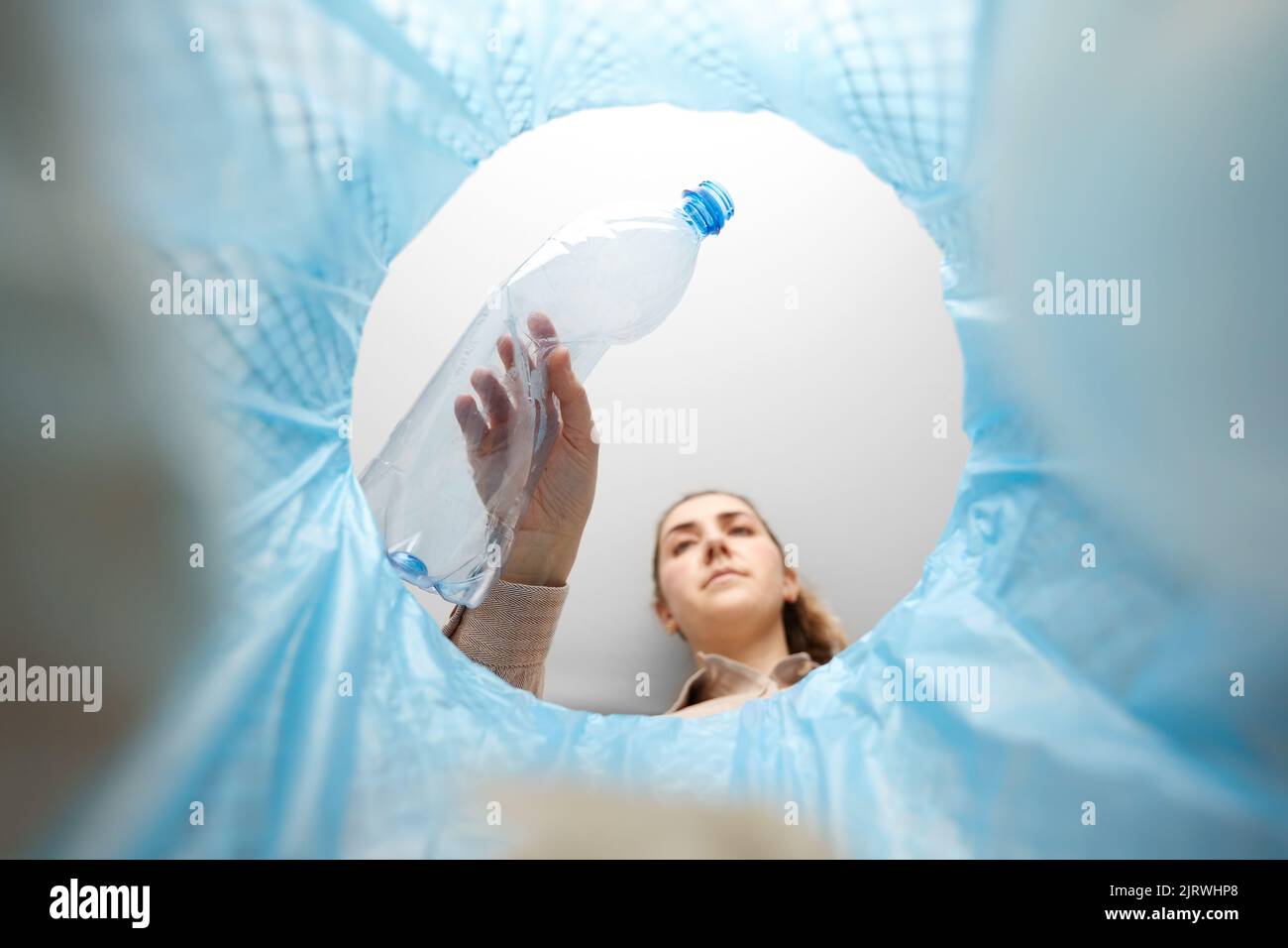 woman throwing plastic bottle into trash can Stock Photo - Alamy