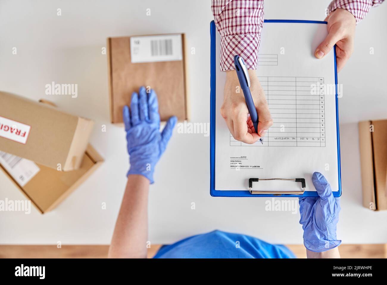 hands with parcel box and customer signing papers Stock Photo - Alamy