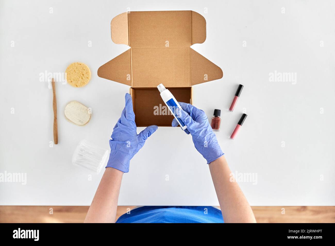 hands in gloves packing parcel box with cosmetics Stock Photo - Alamy