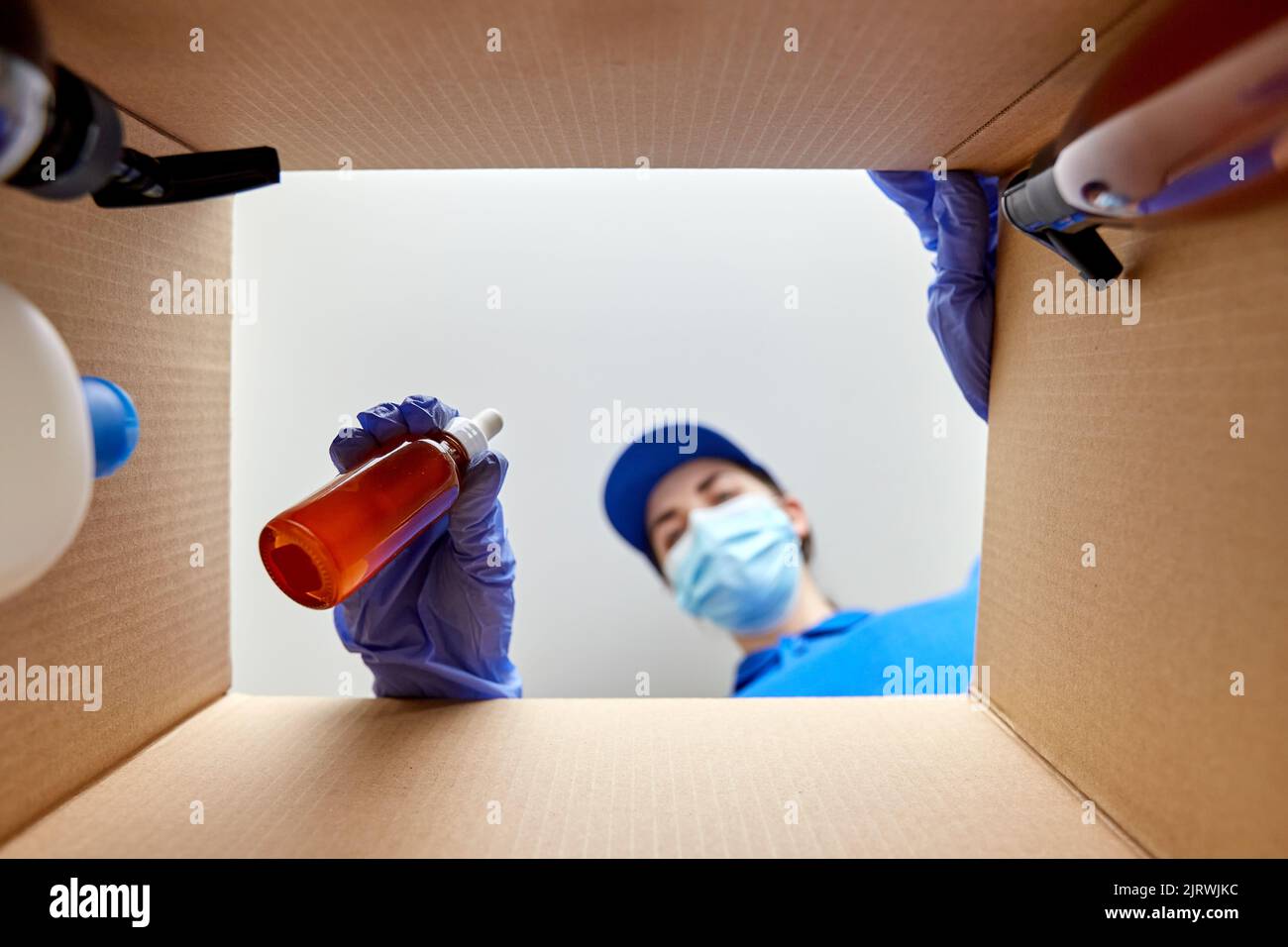 woman in mask packing parcel box with cosmetics Stock Photo - Alamy