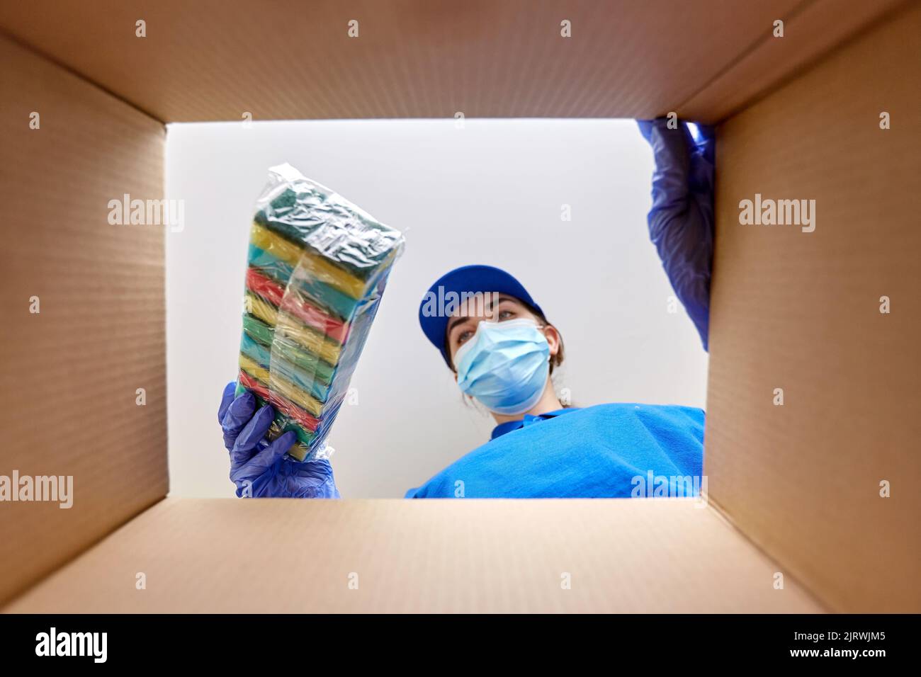 woman in mask packing kitchen sponges to box Stock Photo - Alamy