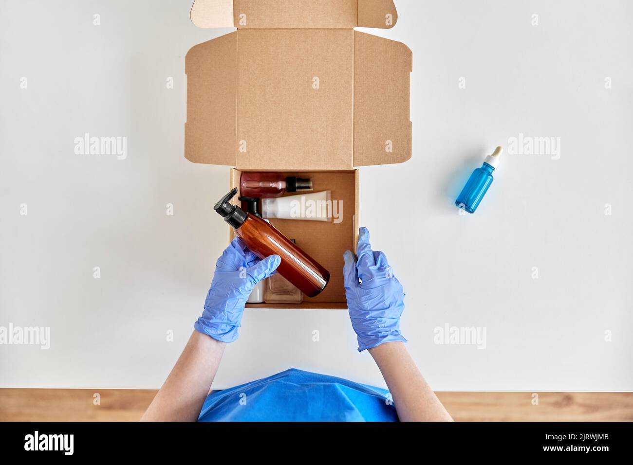 hands in gloves packing parcel box with cosmetics Stock Photo - Alamy