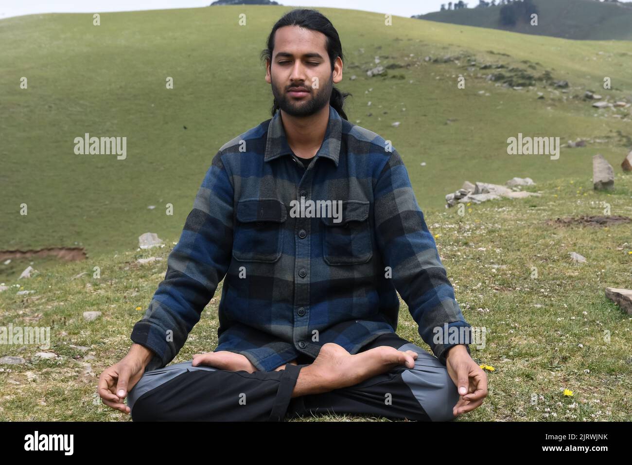Front view of a young Indian guy practicing Meditation, Yoga in Lotus ...