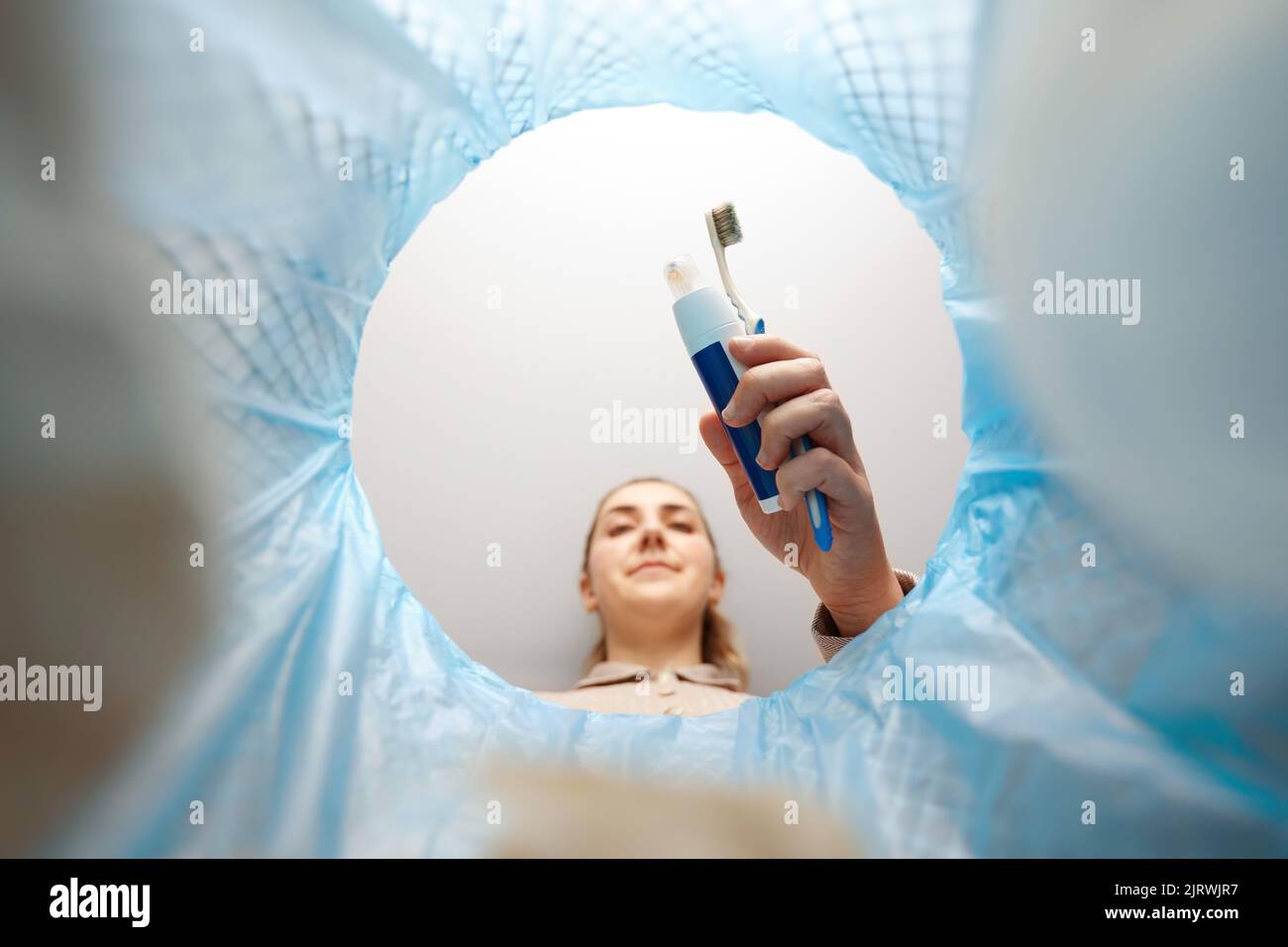 woman throwing toothbrush into trash can Stock Photo - Alamy