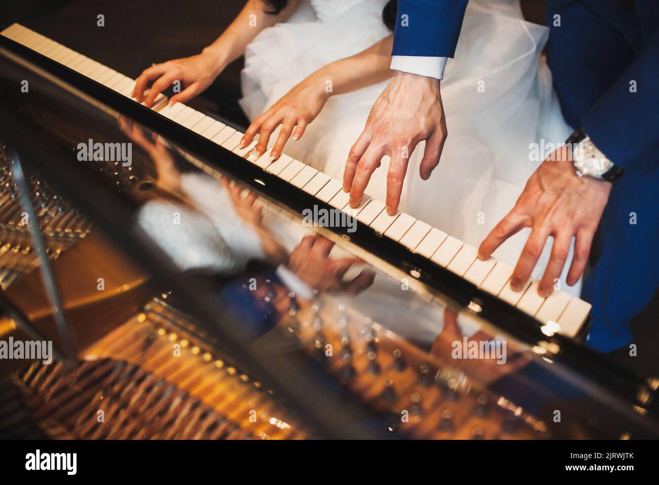 Bride and groom on their wedding day. Newlyweds playing the piano Stock ...